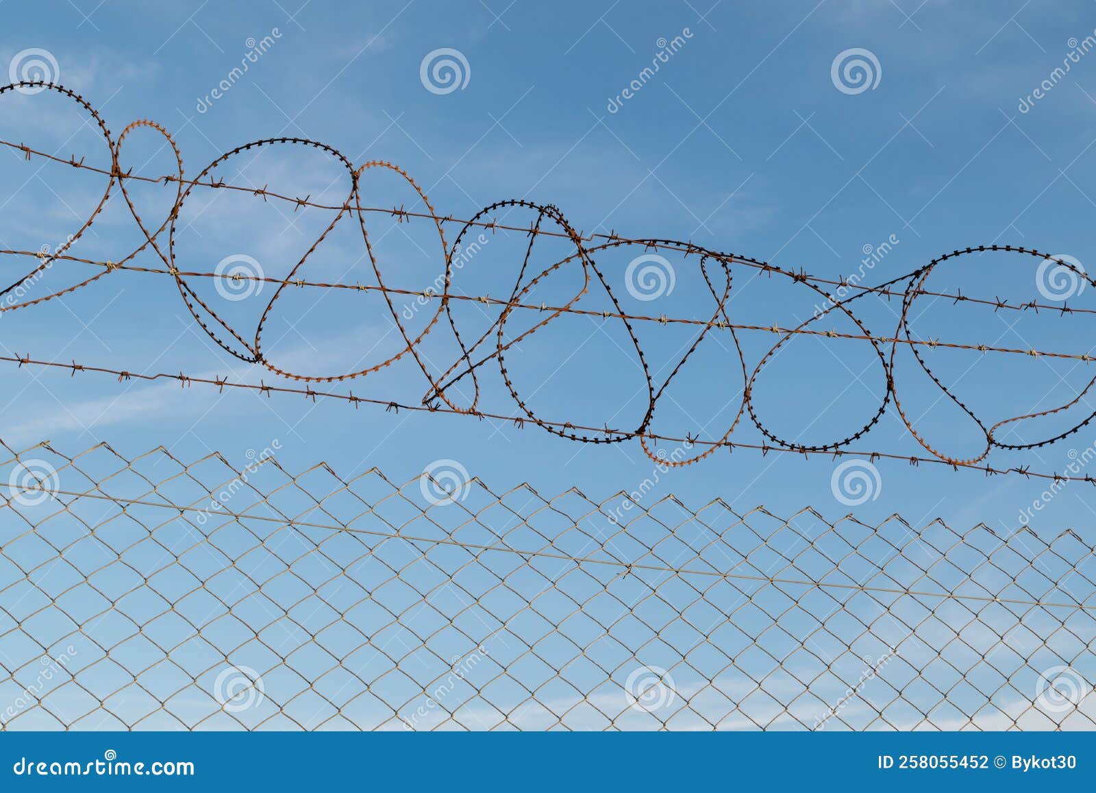 Fence with Barbed Wire Against the Blue Sky. Stock Photo - Image of ...