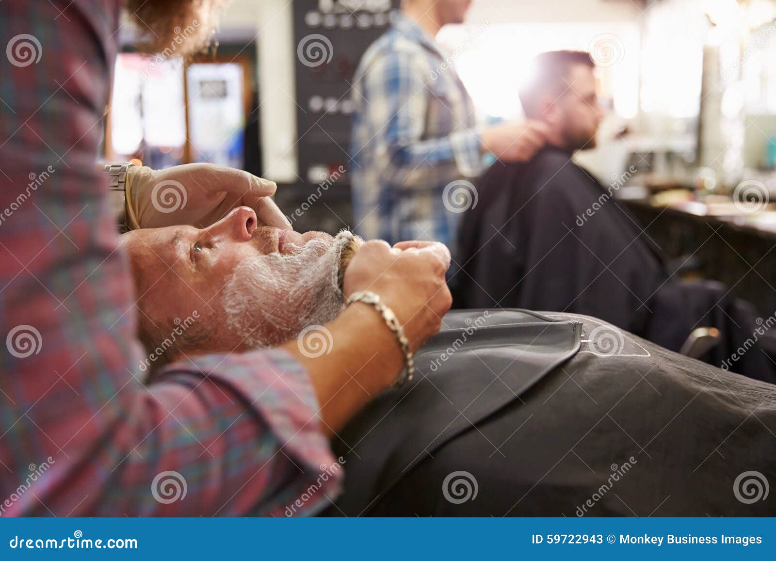 Barber Preparing Client for Shave Masculina En Tienda Imagen de archivo ...