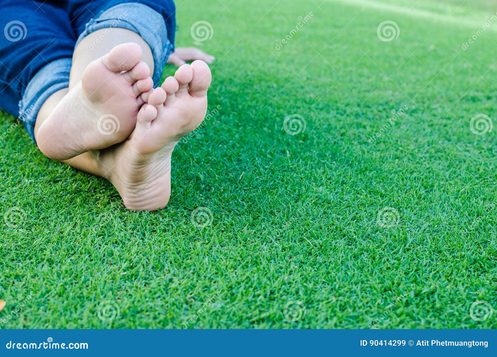 Bare feet on green grass. stock image. Image of flower - 90414299
