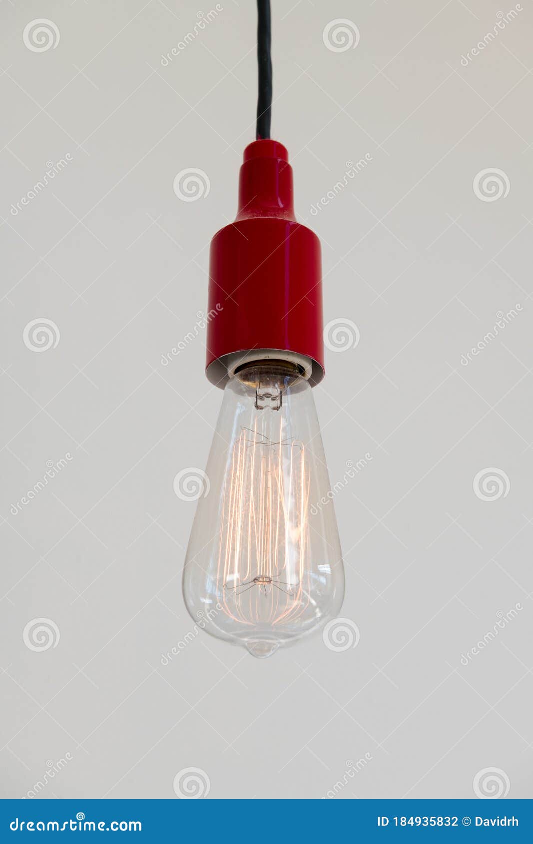 Bare Light Bulb with Detailed Filaments in a Red Fixture Stock Photo ...