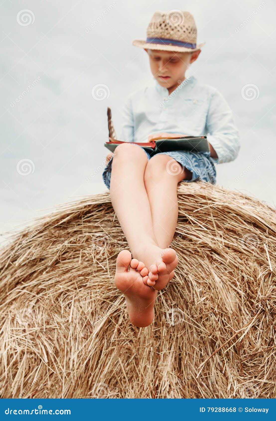 Barefoot Boy Reads a Book Sits on the Top of Haystack Stock Photo ...