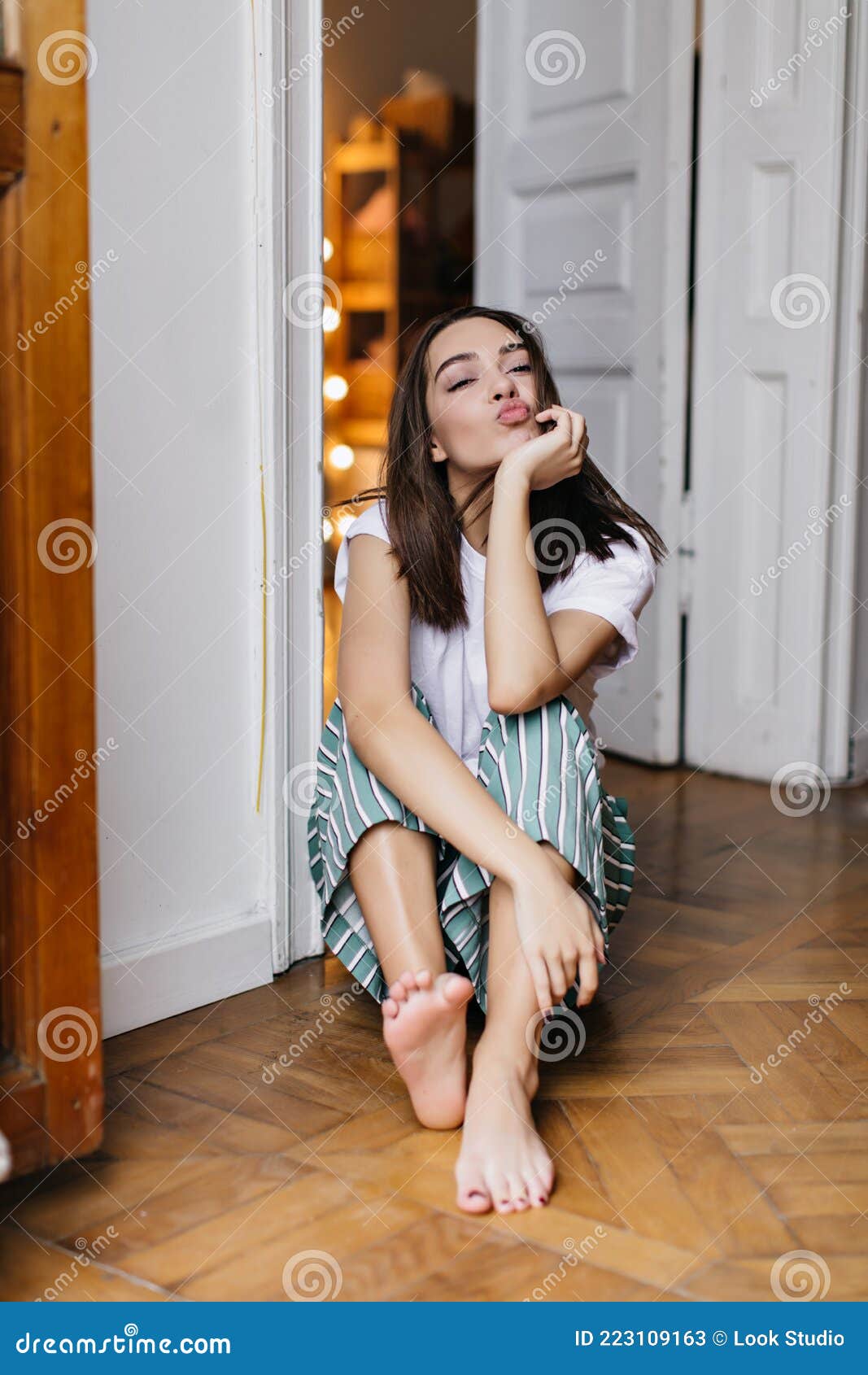 Barefooted Cute Girl Sitting On The Floor At Home And Fooling Around