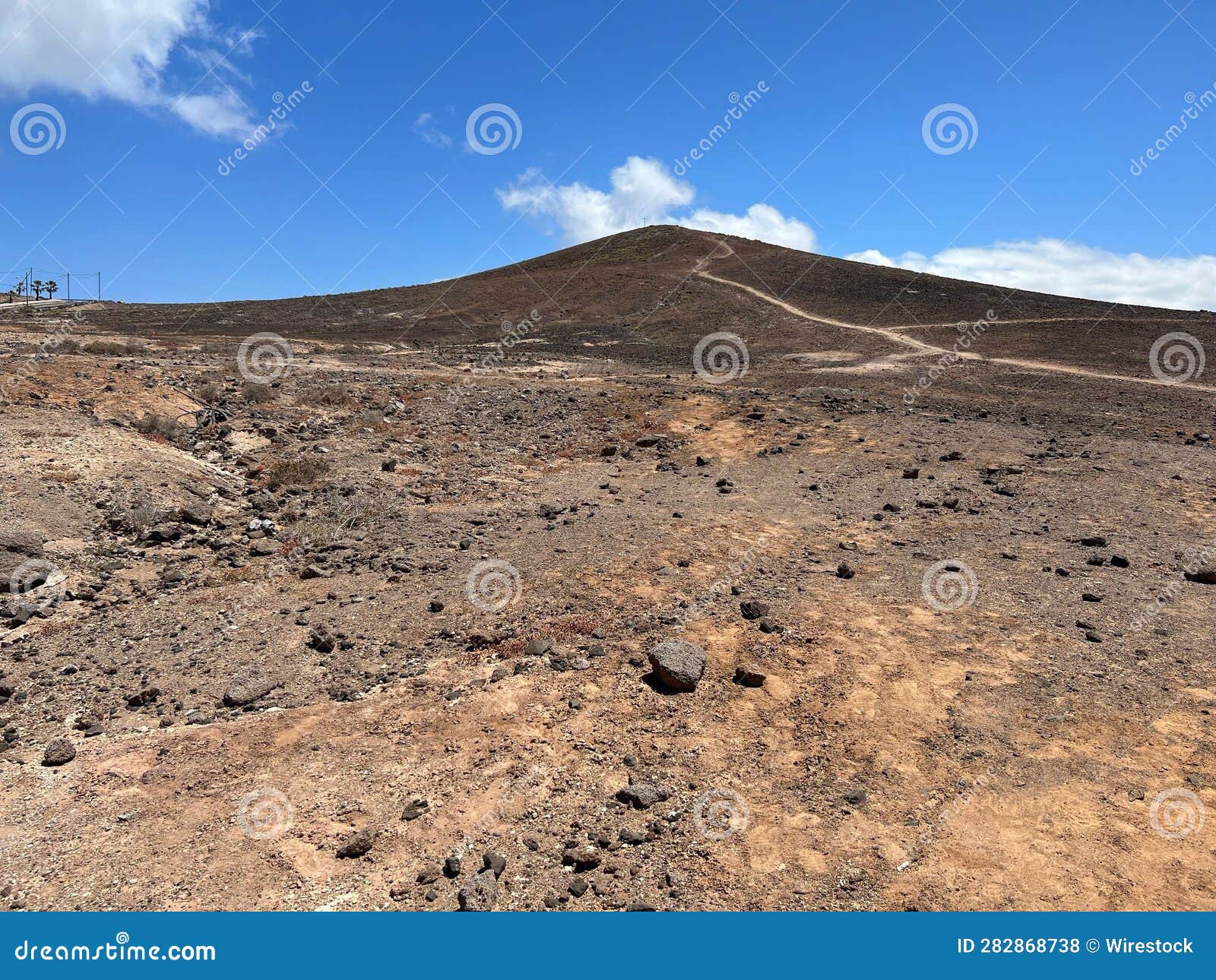 A Dirt and Rock Covered Field with a Hill in the Background Stock Photo ...