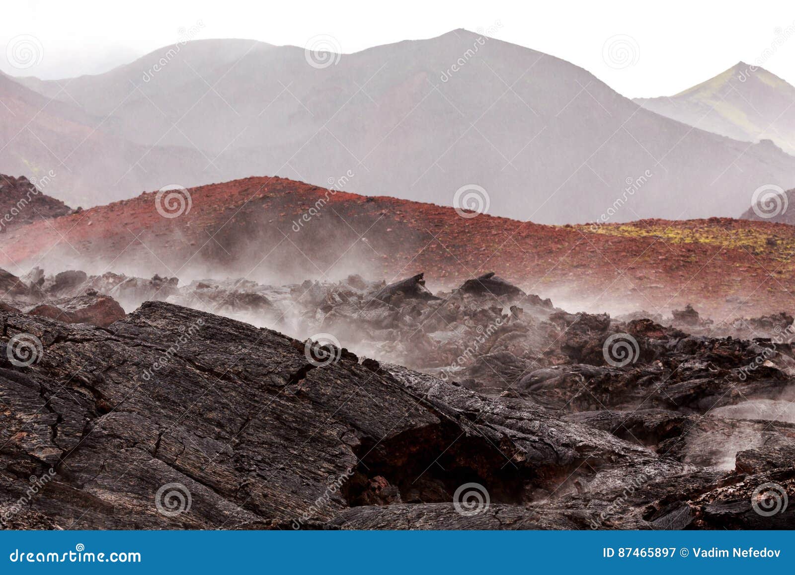 Barren Lava Fields Steaming in Light Rain with Volcanoes in Back Stock ...