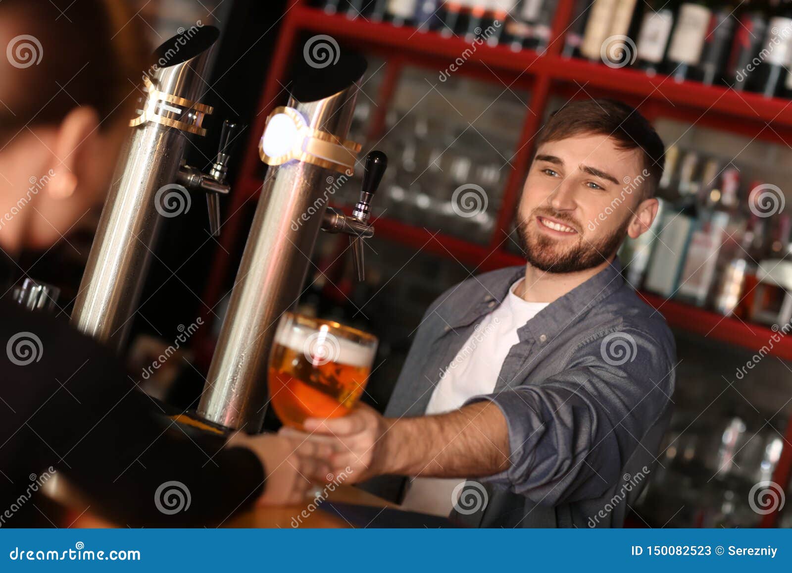 Bartender Giving Glass of Beer To Waitress in Bar Stock Image - Image ...