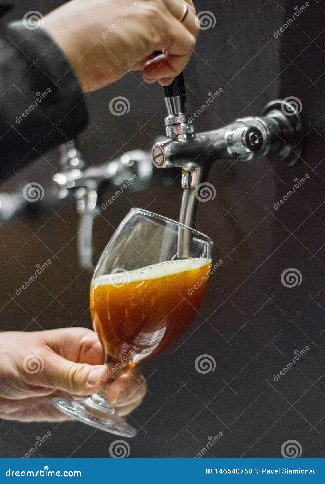 Bartender Hand at Beer Tap Pouring a Draught Beer in Glass Serving in a ...