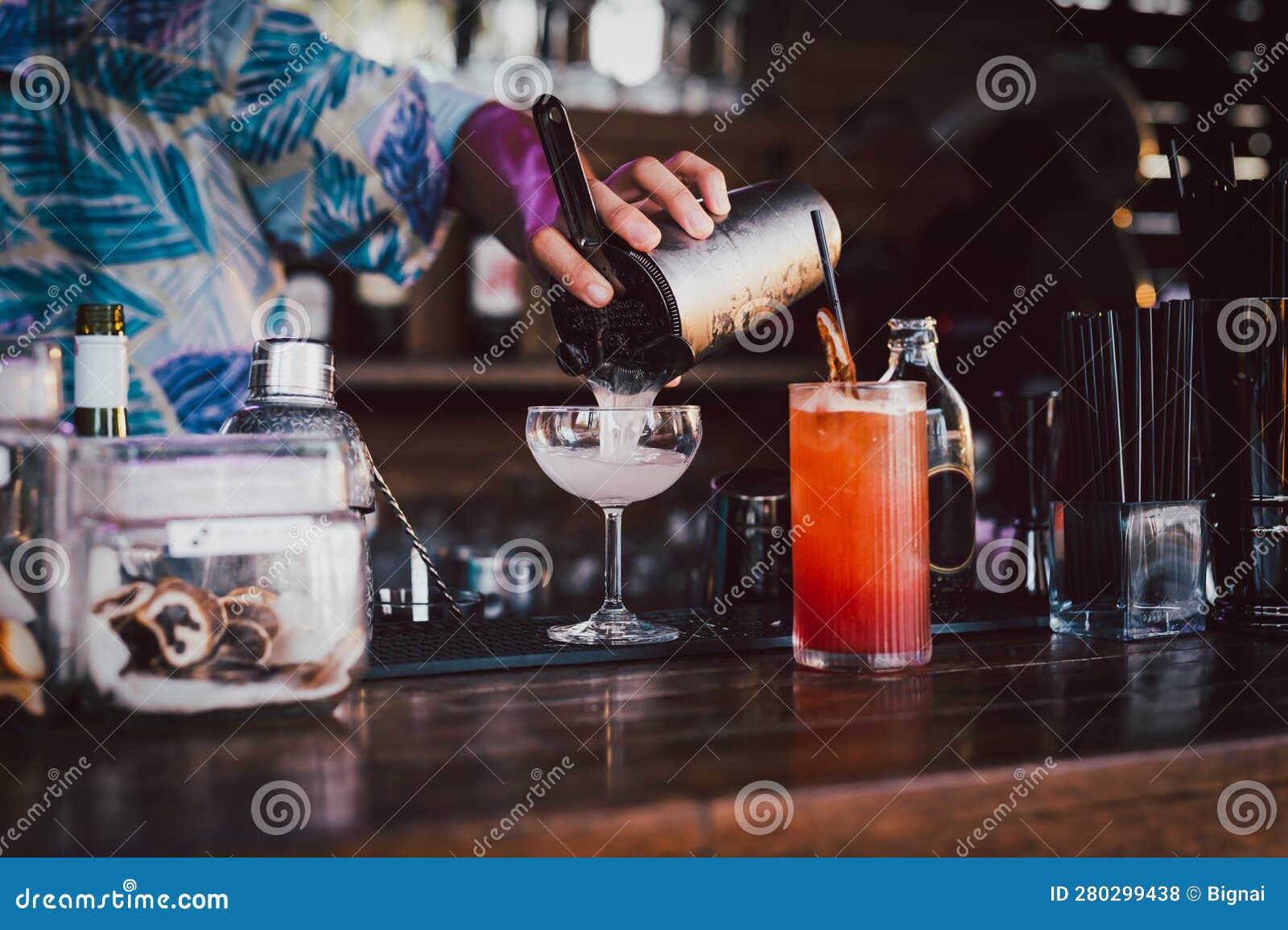 Bartender Making Cocktail Pouring into a Martini Glass. Stock Photo ...