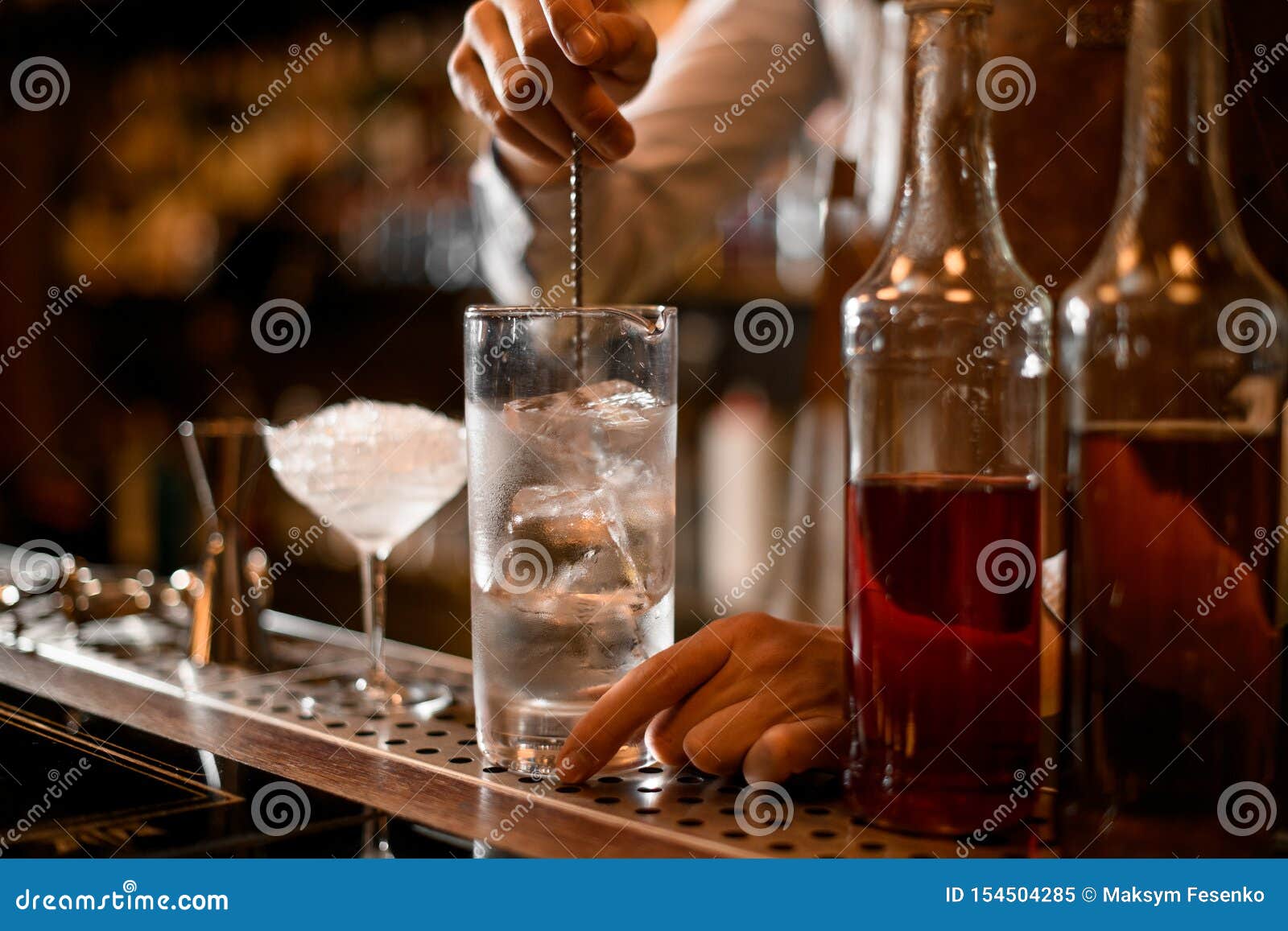 Bartender Stirring With A Spoon A Yellow Achoholic Drink In A Co Stock ...