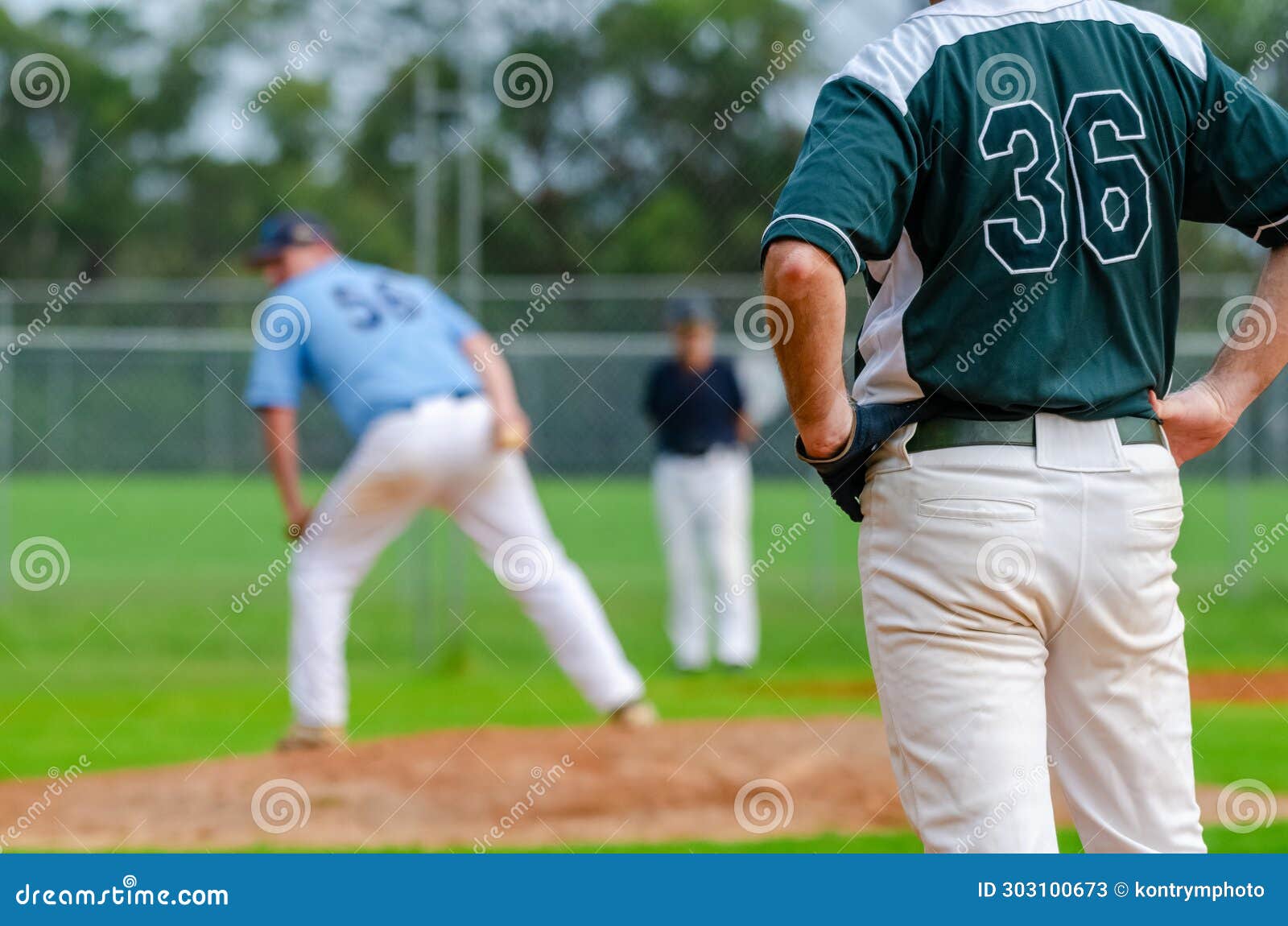 Baseball Game, Runner on the First Base is Watching the Pitcher and ...
