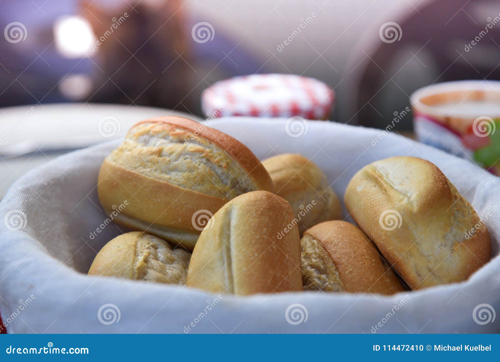 Basket of Freshly Baked Dinner Rolls with Tableware in Background ...