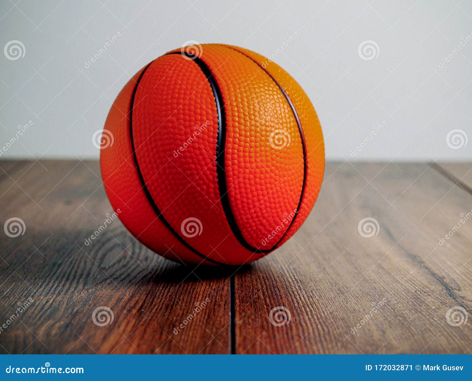 Basketball on a Dark Wooden Floor. Light Grey Background Stock Image ...