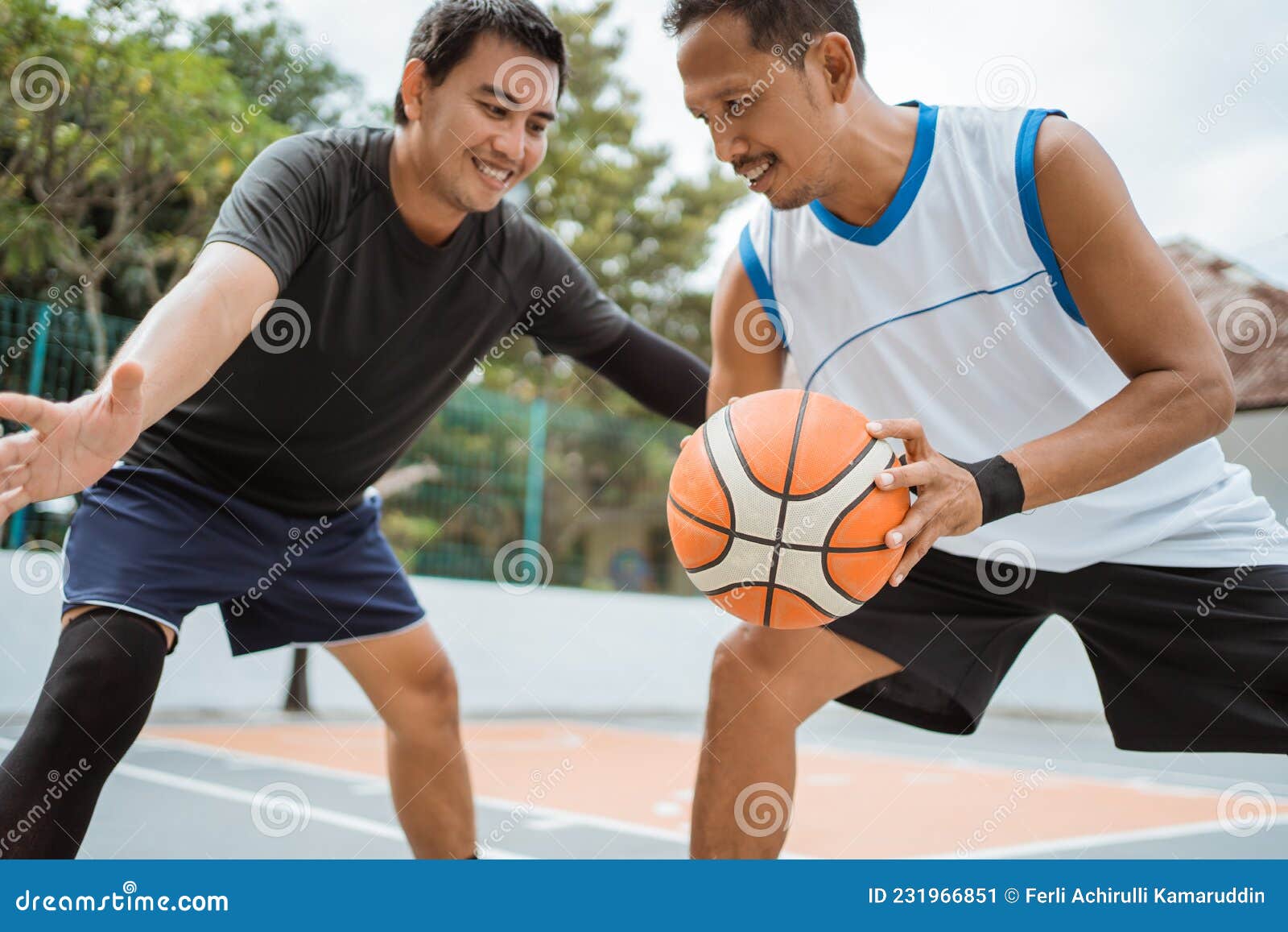 A Basketball Player Performs Low Dribbling when Confronted by an ...