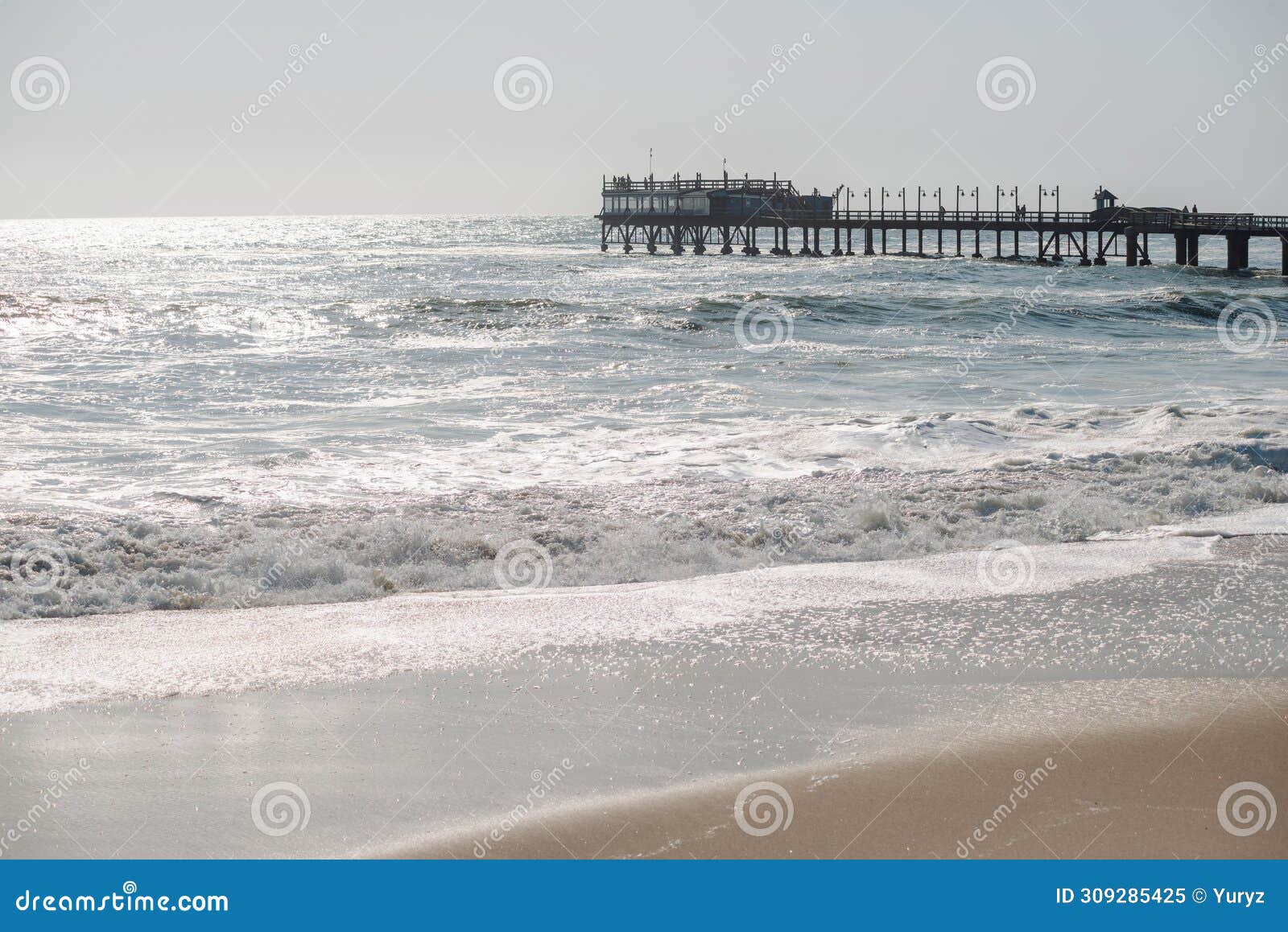 Beach with distant pier stock image. Image of landmark - 309285425