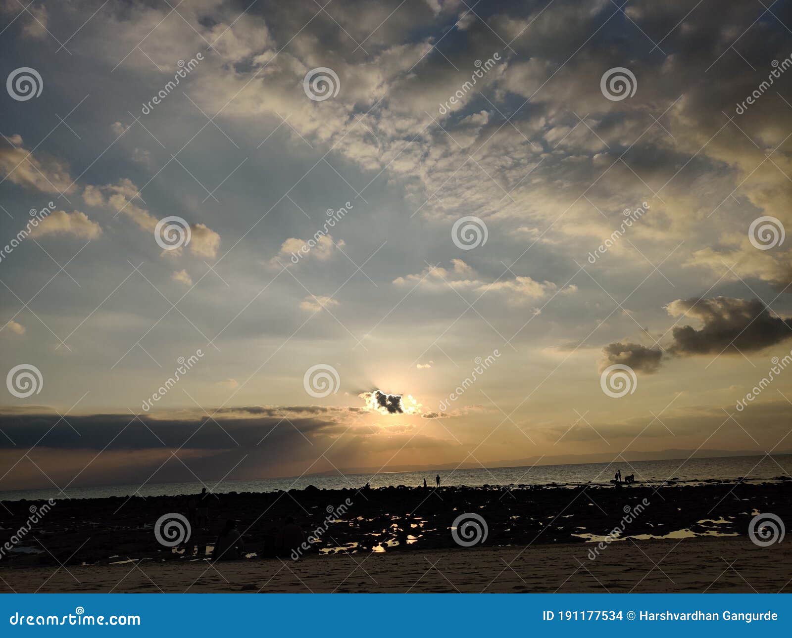 Beach Life with Sun Settling Down Under Skies Stock Photo - Image of ...