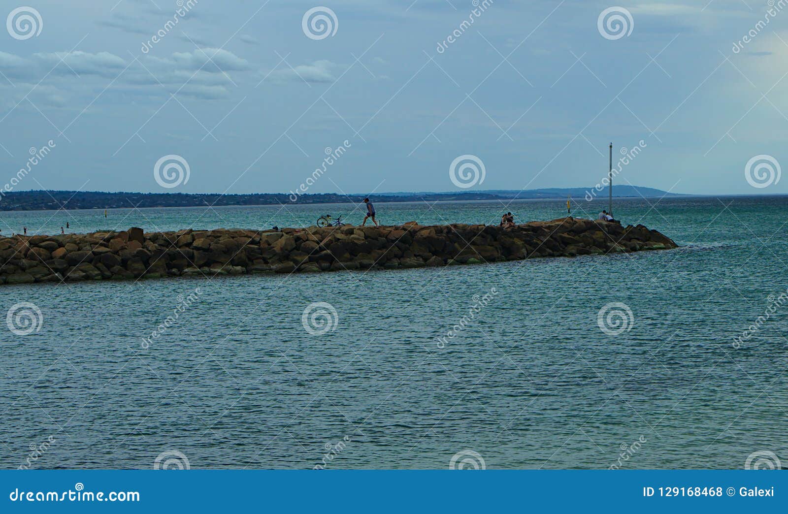 Beach rocks from distant stock photo. Image of liquid - 129168468