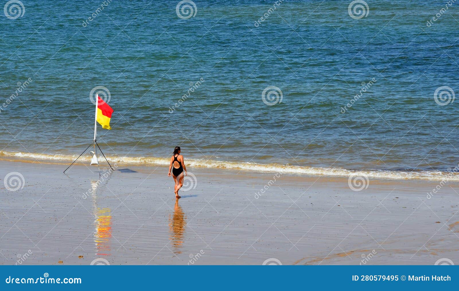 Beach with Safe Bathing Flag and Lone Figure Stock Image - Image of ...