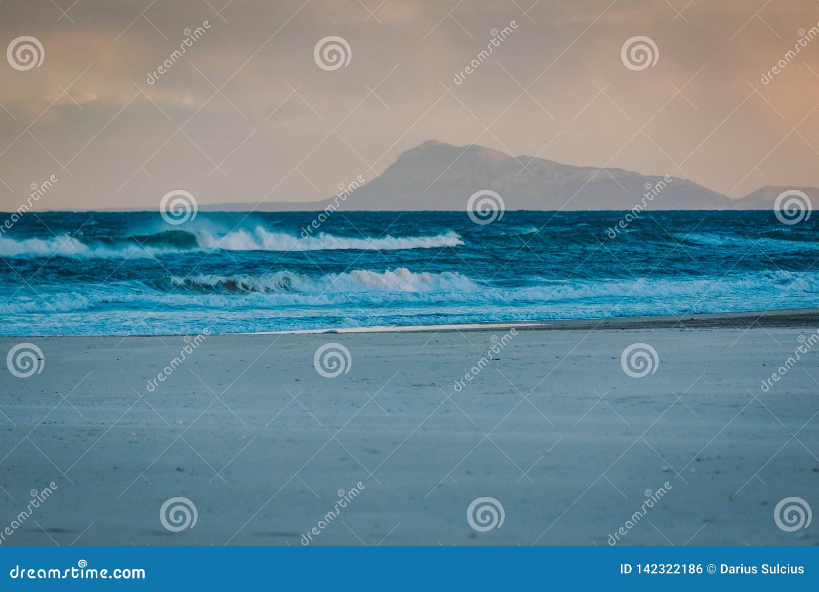 Beach Scenery with Blue Waves, Dramatic Sky and Mountains in the ...