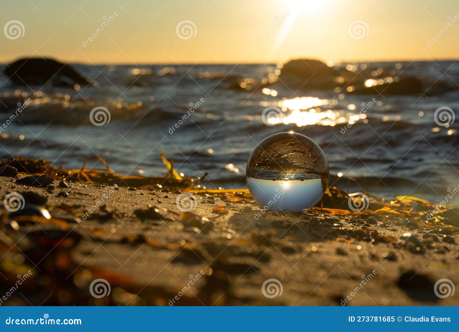 The Beach and the Sea are Reflected in a Sphere Lying in the Sand Stock ...