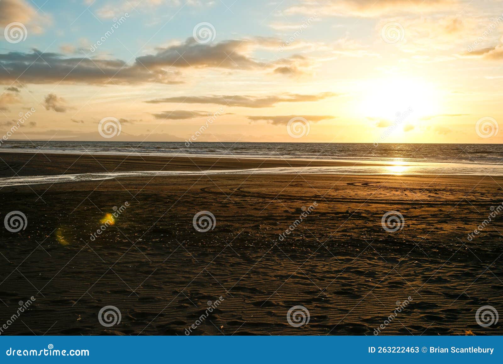 Beach in Silhouette As Sunsets on Distant Horizon Over Ocean Stock ...