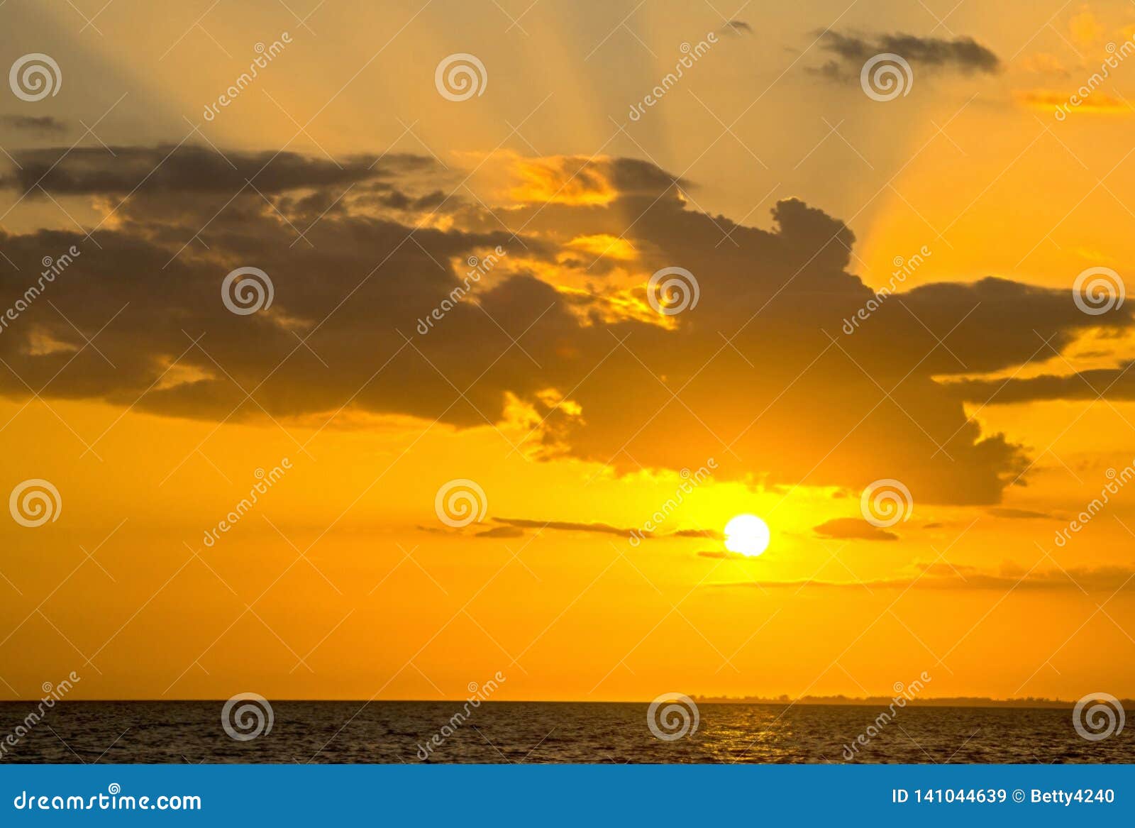 Beach Sunset with Rays Shooting Up through Clouds. Stock Image - Image ...