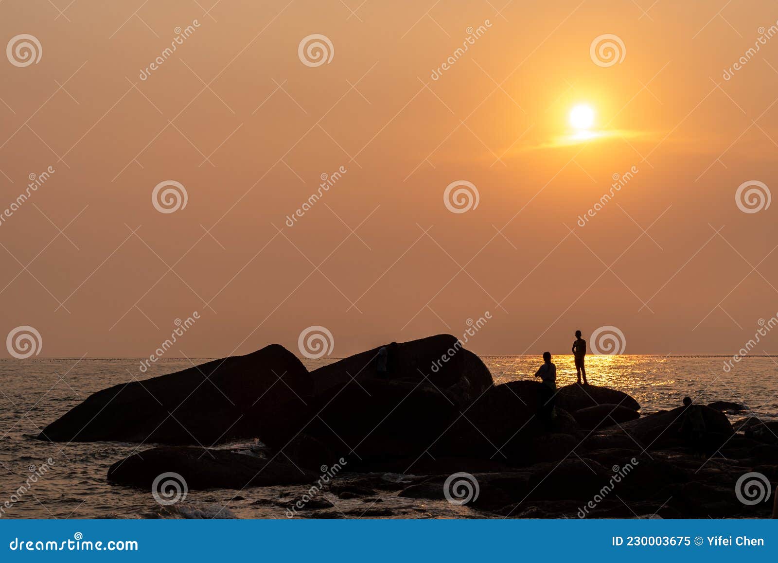 The Beach Under the Setting Sun is Golden, and the People Playing by ...