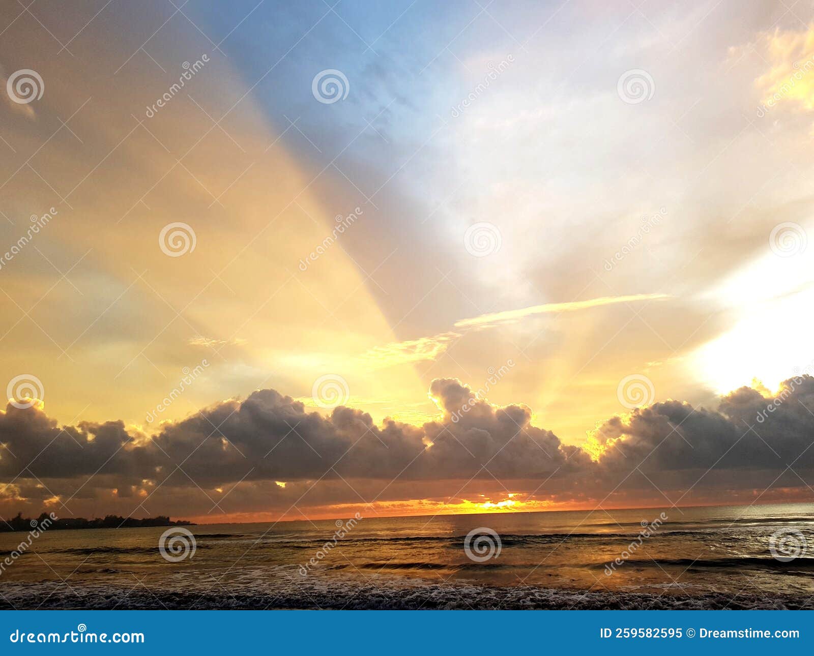 Beachside Sunset View with Rays of Light in the Clouds, with Waves ...