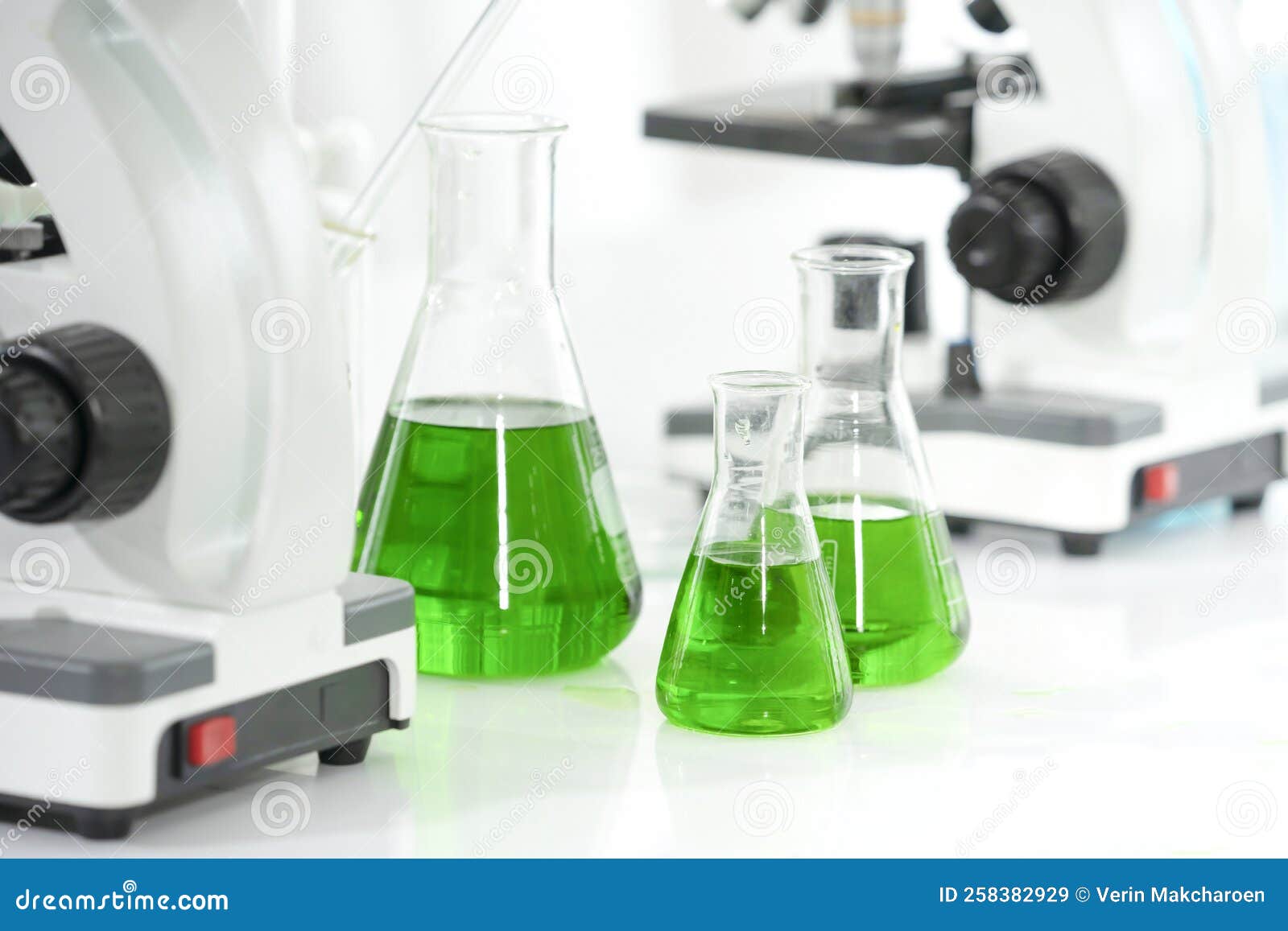 Beaker of Green Chemical on Table with Blurred Microscope Stock Image ...