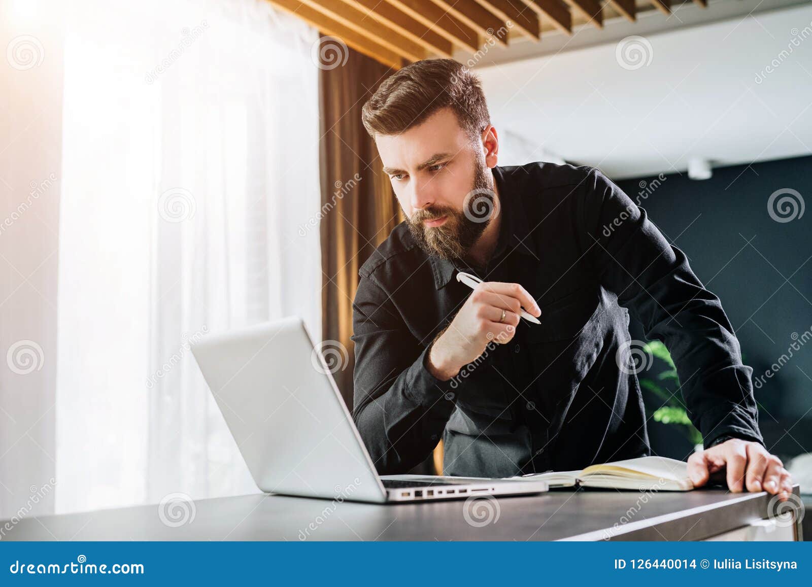 Bearded Businessman is Standing by Computer, Looking Thoughtfully at ...