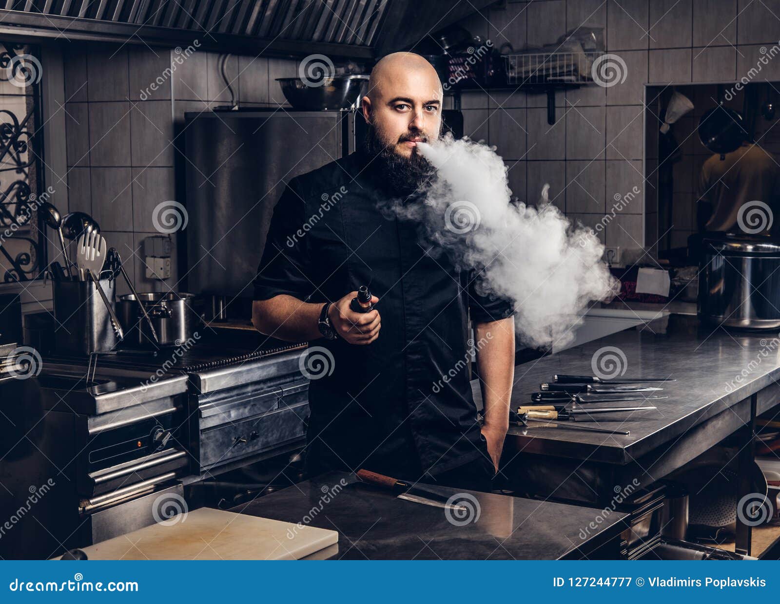 Bearded Chef in Black Uniform Smoking E-cigarette while Standing in the ...