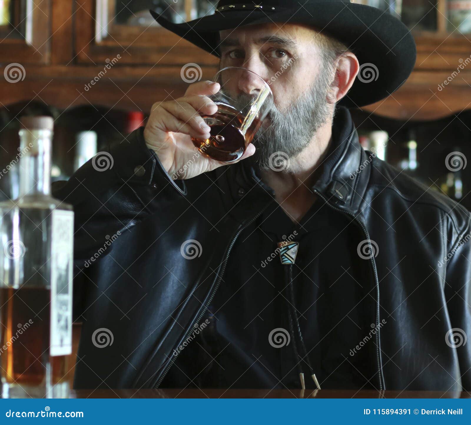 A Bearded Cowboy in Black Drinking Alone in a Saloon Stock Image ...