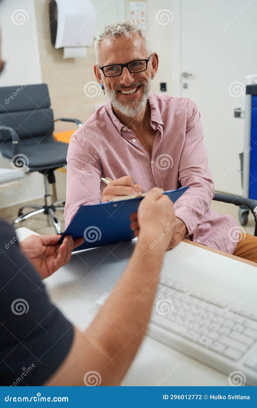 Bearded Elderly Man Signing Documents in Doctors Office Stock Photo ...