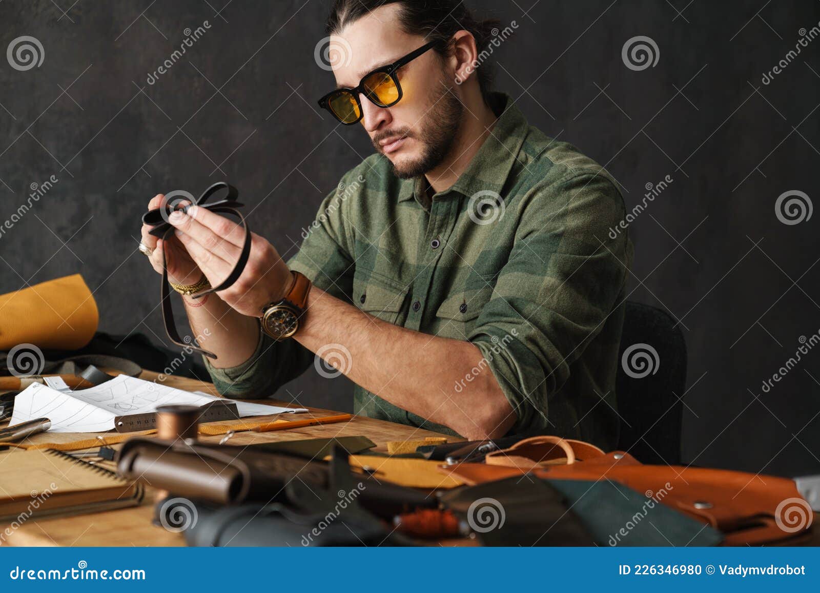 Bearded Focused Craftsman Working with Leather while Sitting at Table ...