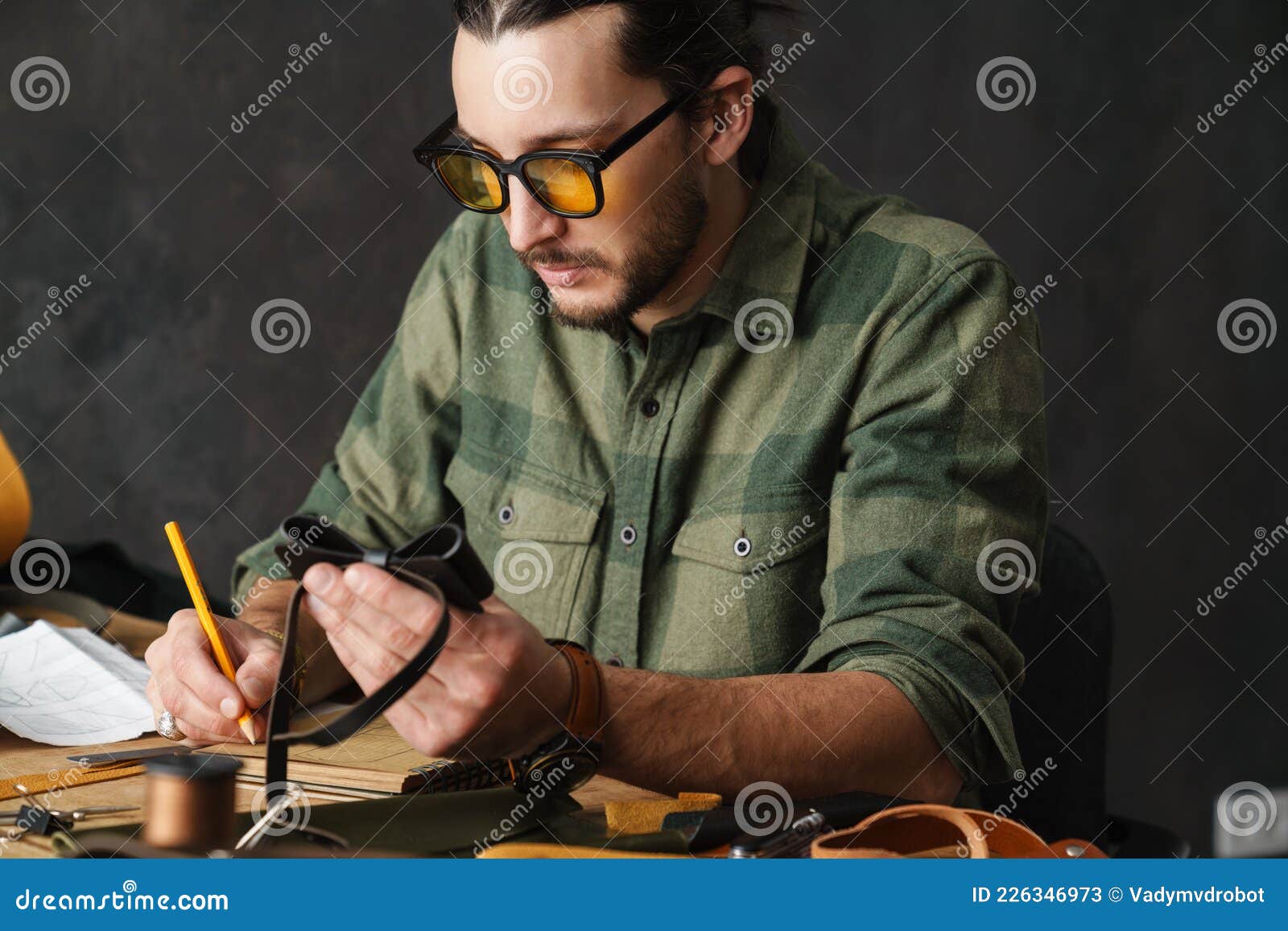 Bearded Focused Craftsman Working with Leather while Sitting at Table ...