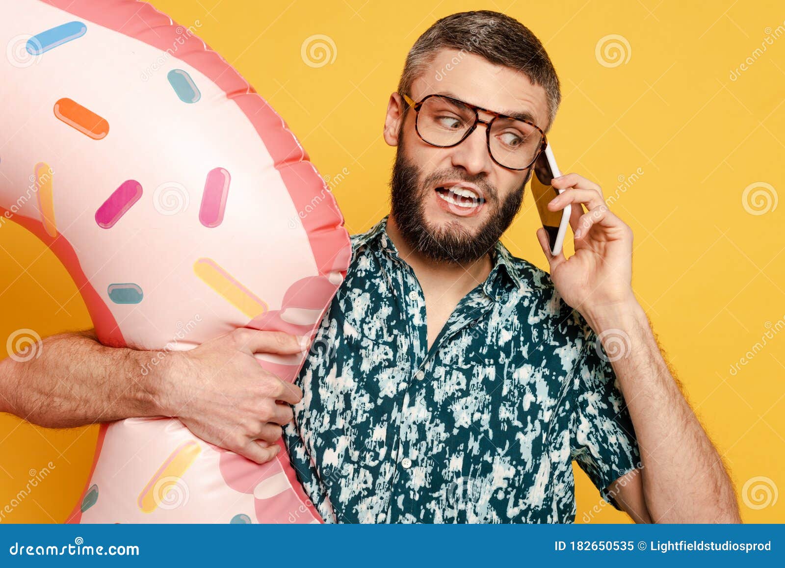 Bearded Guy In Glasses With Donut Swim Ring Talking On Smartphone On