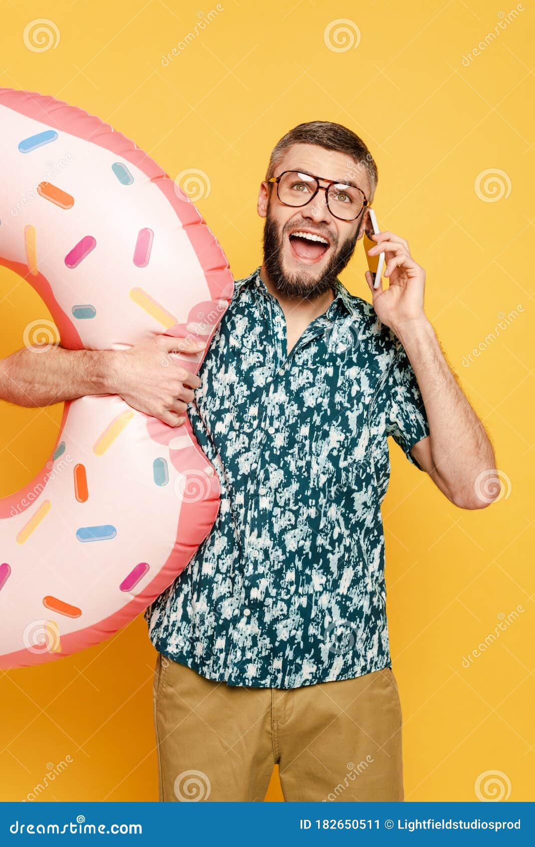 Bearded Guy In Glasses With Donut Swim Ring Talking On Smartphone On