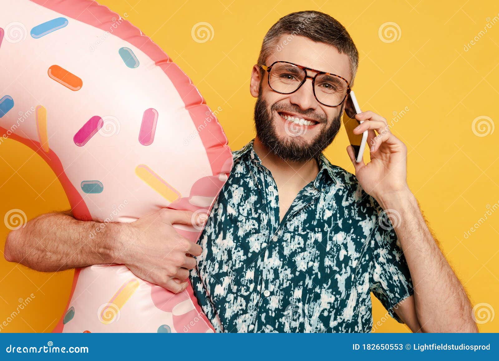 Bearded Guy In Glasses With Donut Swim Ring Talking On Smartphone On