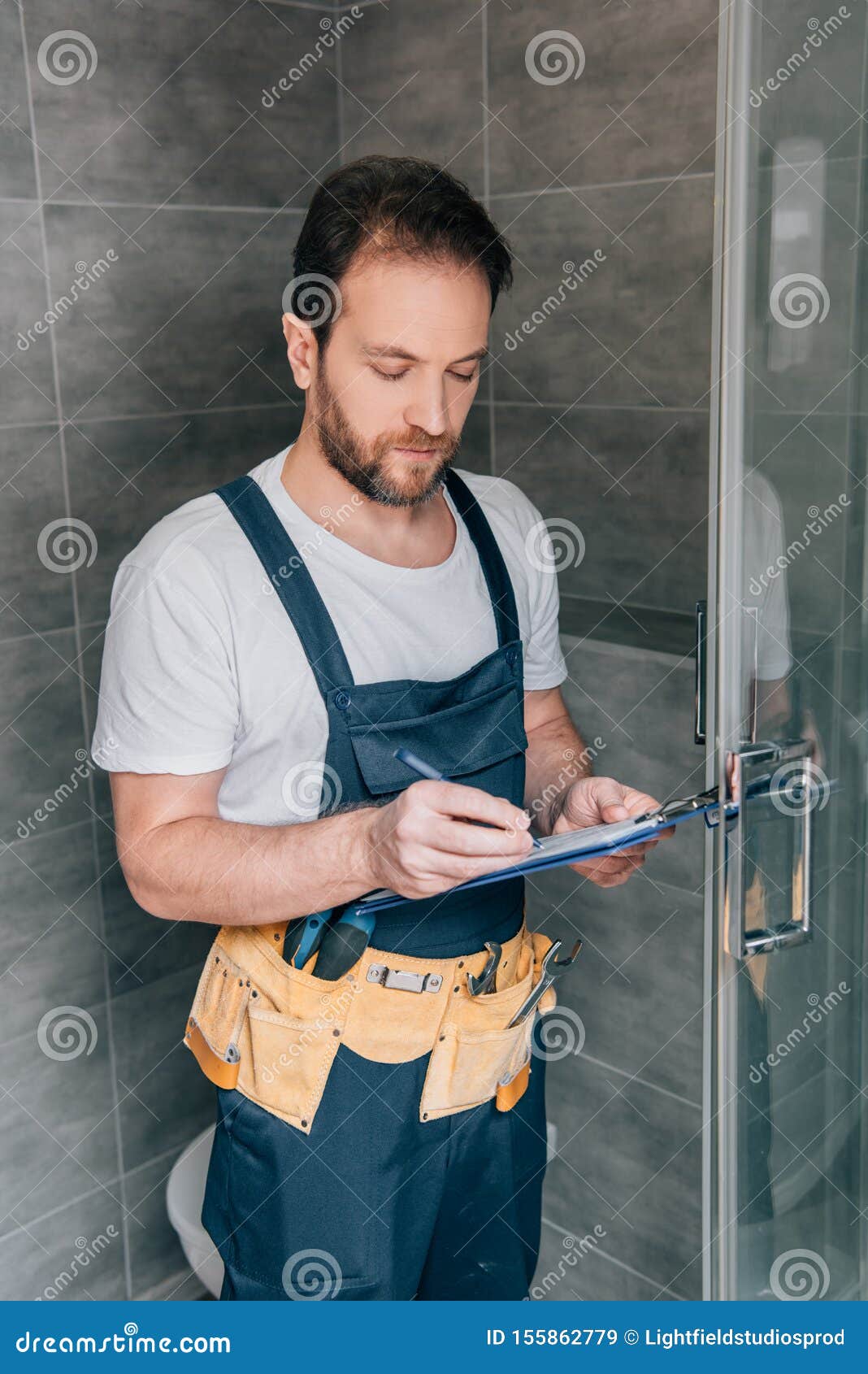 Bearded Male Plumber Making Notes in Clipboard while Checking Shower ...