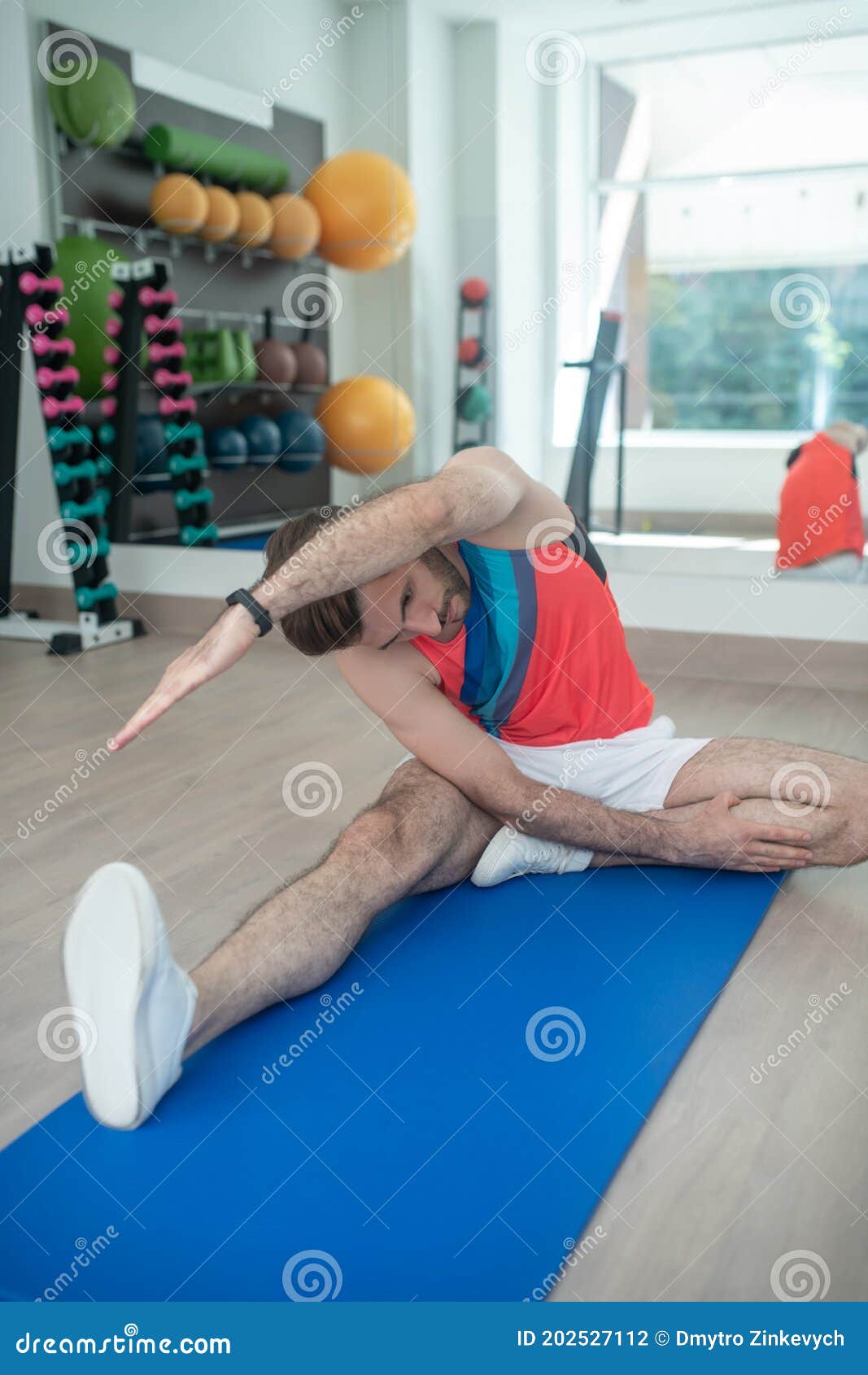 Bearded Male Sitting on the Mat, Bending Forward, Stretching Hamstring ...