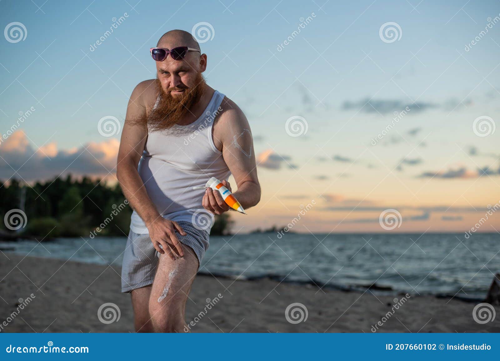 Bearded Man Applying Sunscreen on Body while Standing on the Beach ...