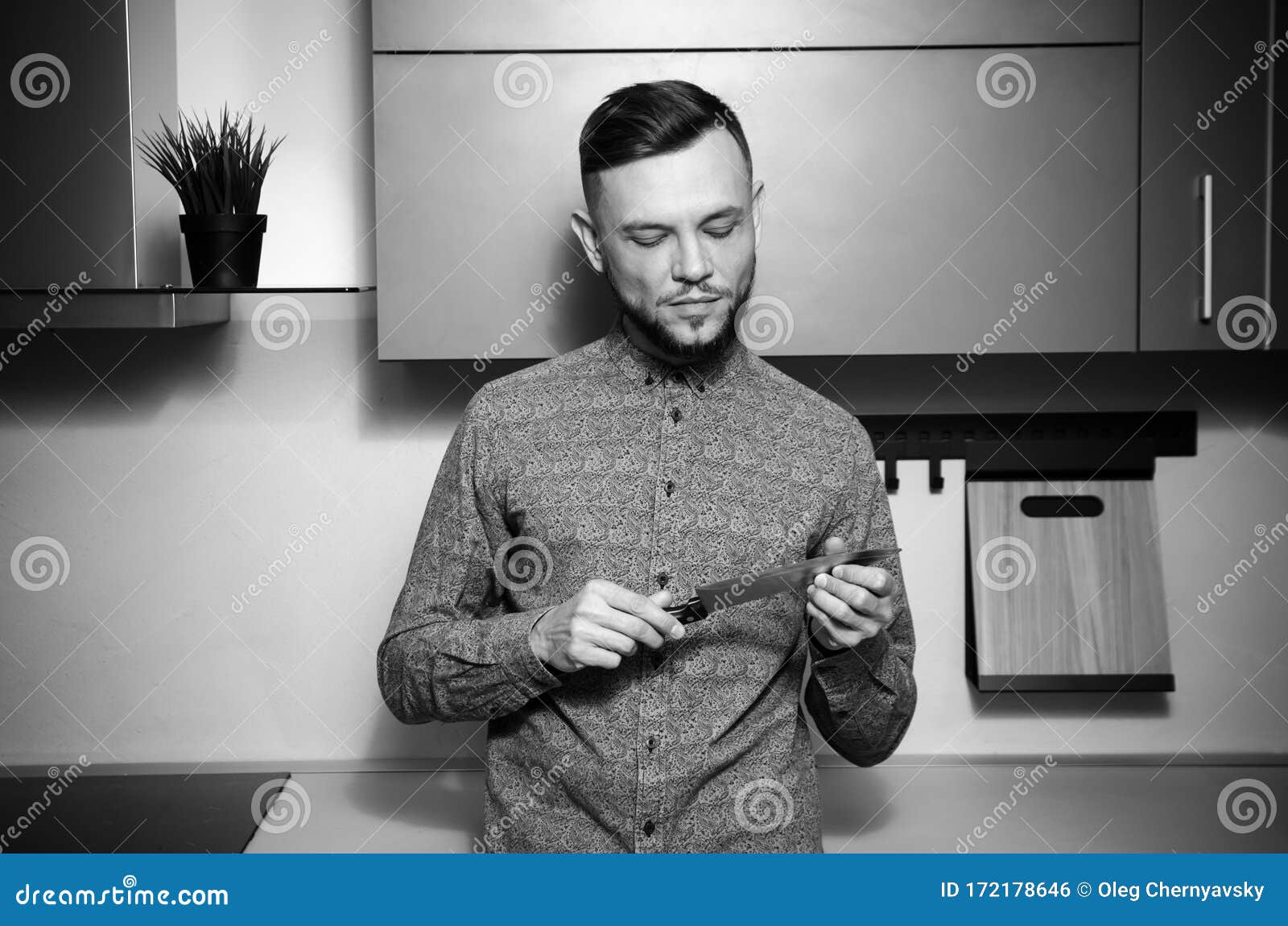 Bearded Man Checks the Sharpness of the Blade at the Knife in His Hands ...