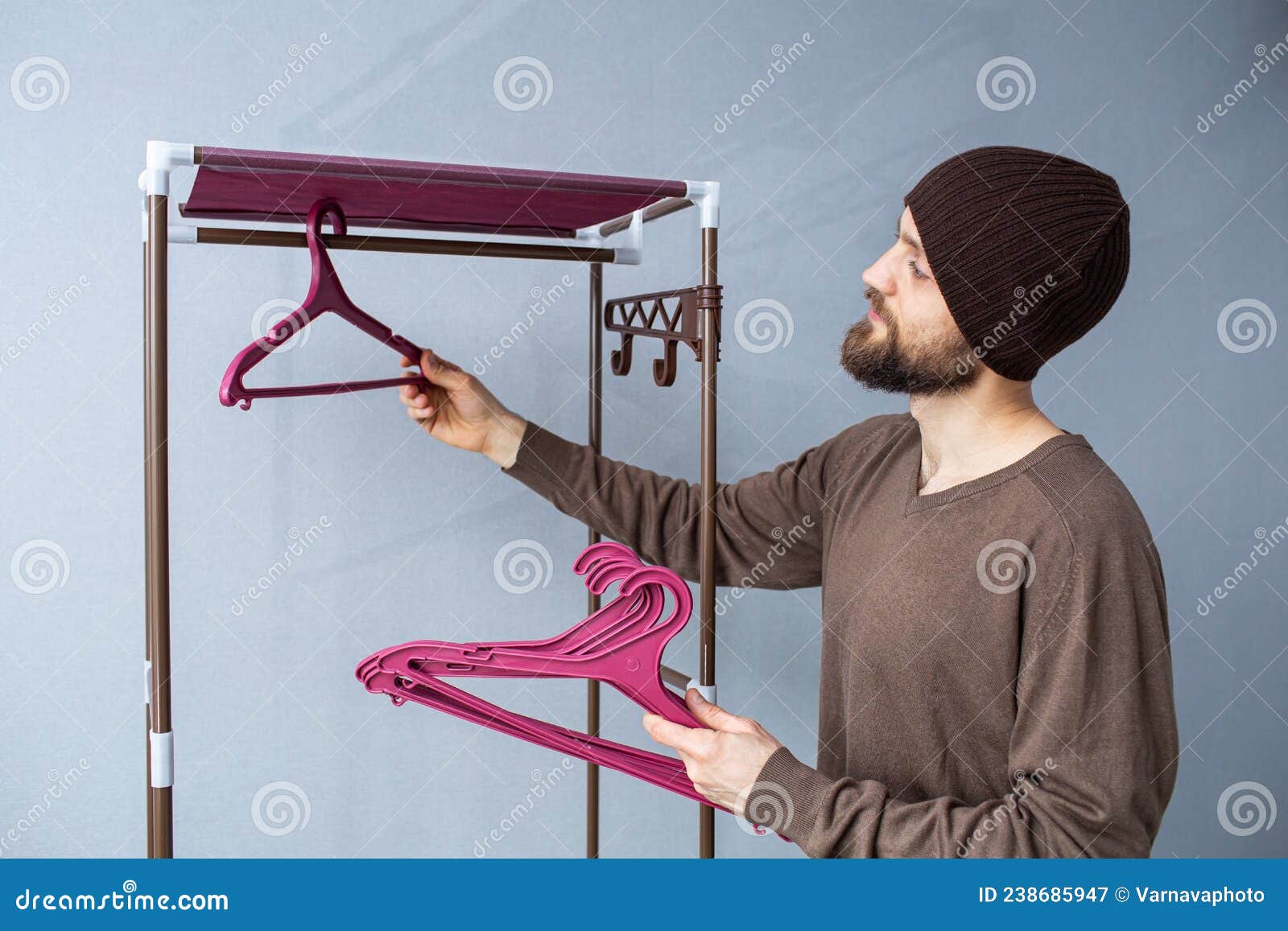 A Bearded Man Hangs Hangers on a Hanger Rack. Stock Image - Image of ...