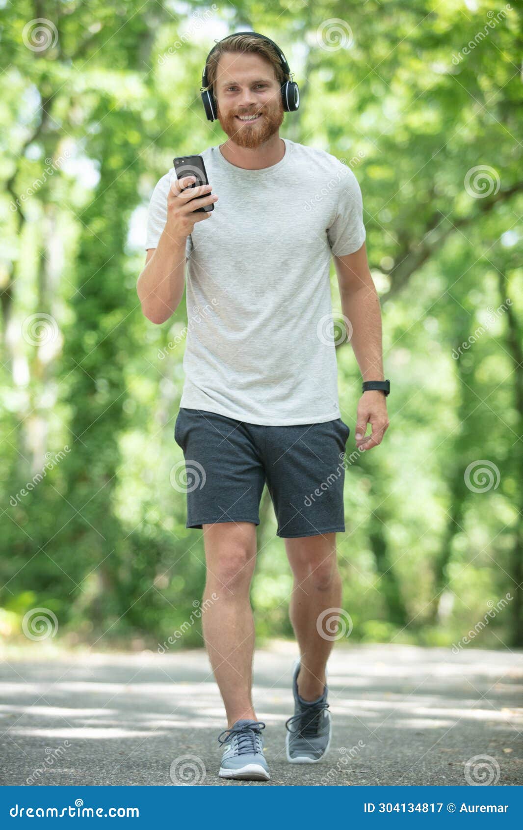 Bearded Man with Headphones Smiling and Running in Park Stock Image ...