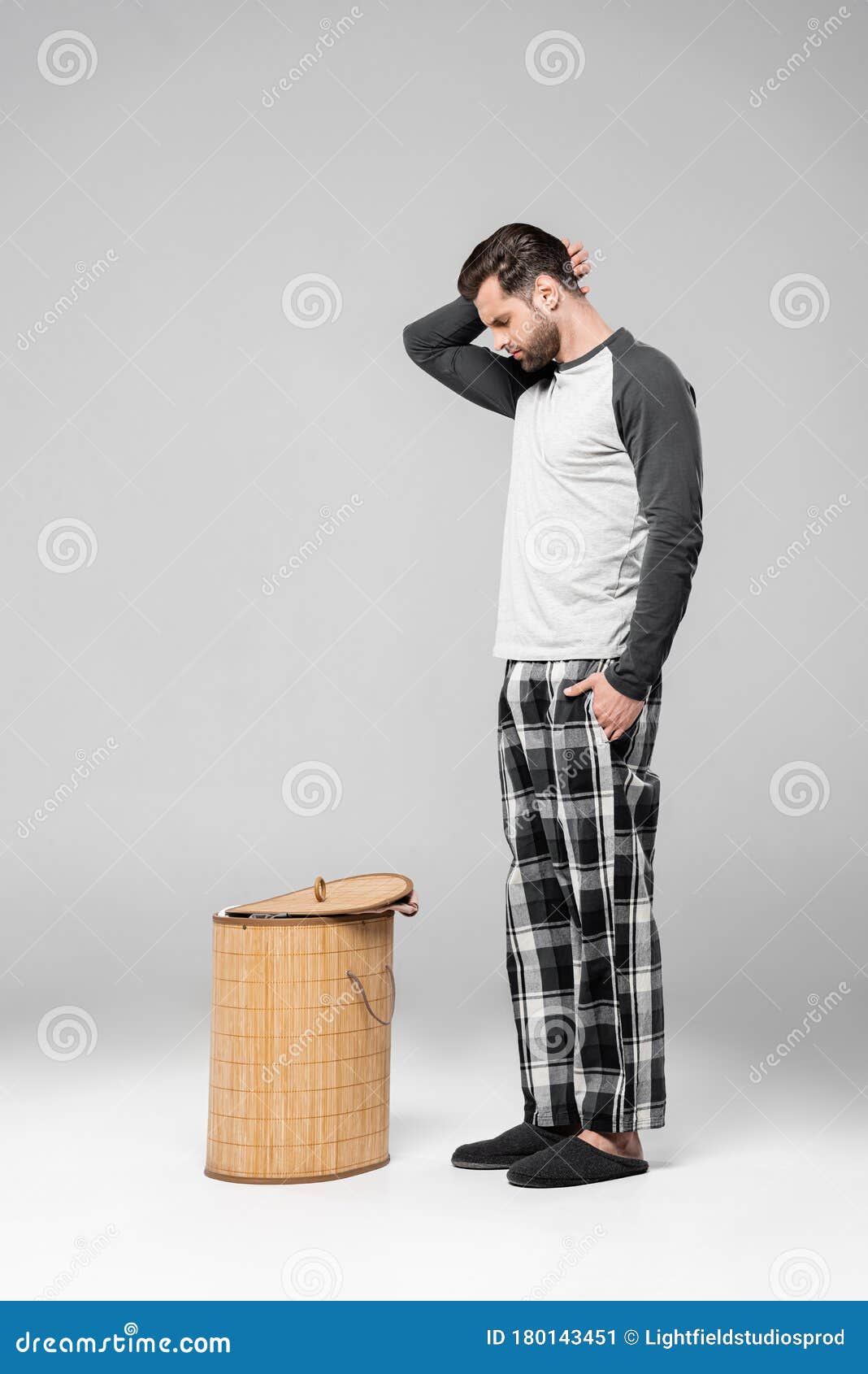 Man Looking at Laundry Basket on Grey Stock Image - Image of handsome ...