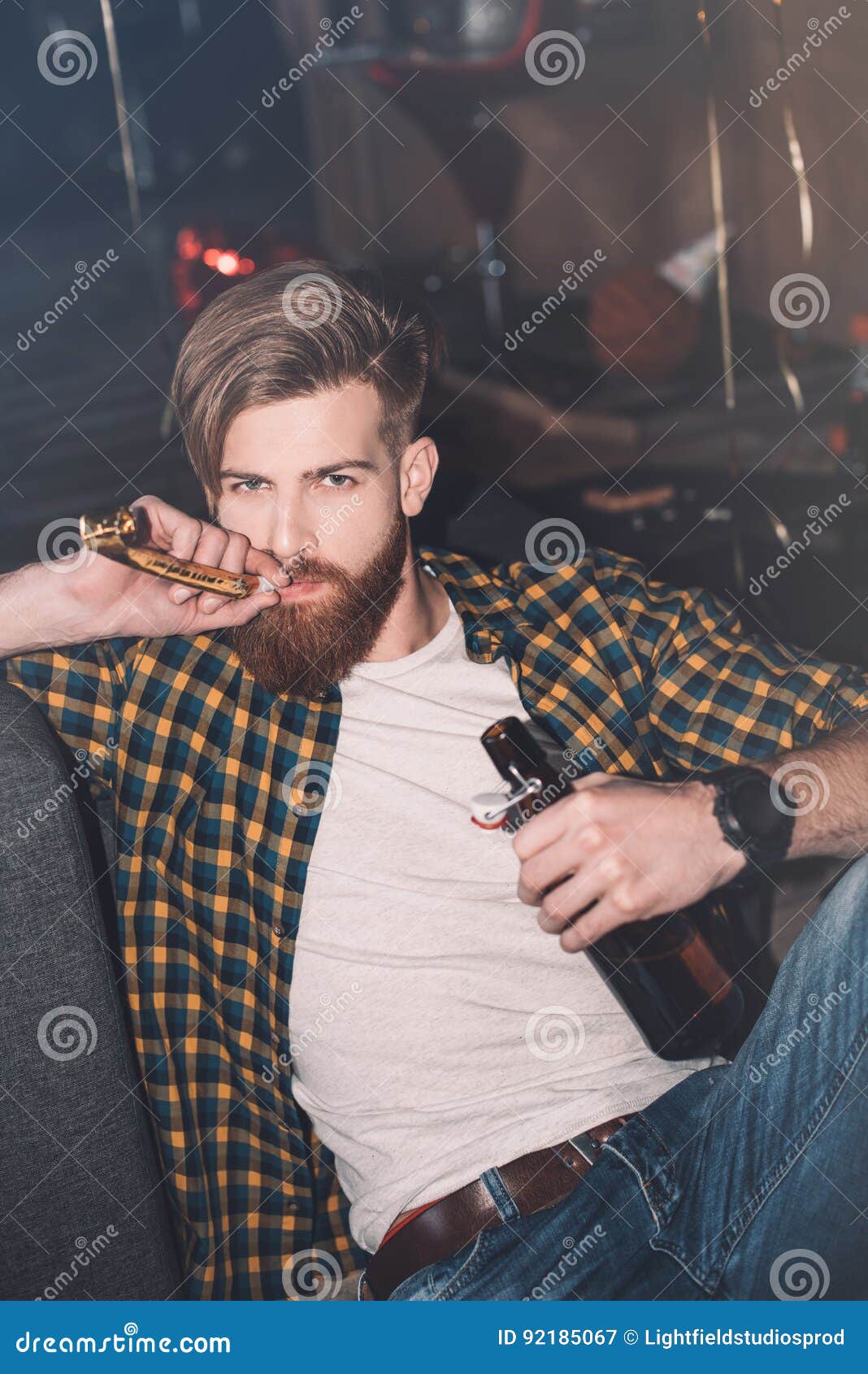 Bearded Man with Party Blower Holding Beer Bottle and Looking at Camera ...