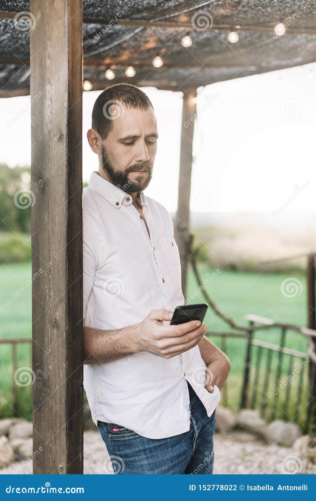 Bearded Man Standing at Countryside Home while Using a Mobile Phone ...