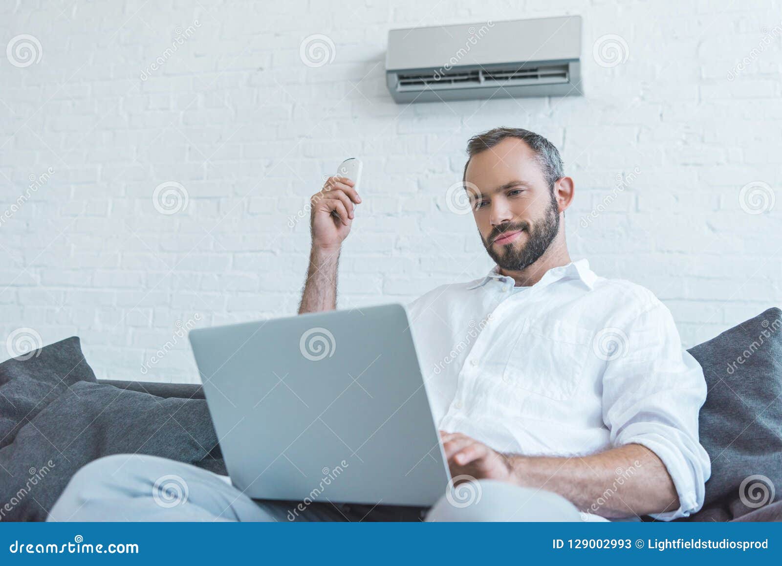 Bearded Man Turning on Air Conditioner with Remote Control while Stock ...