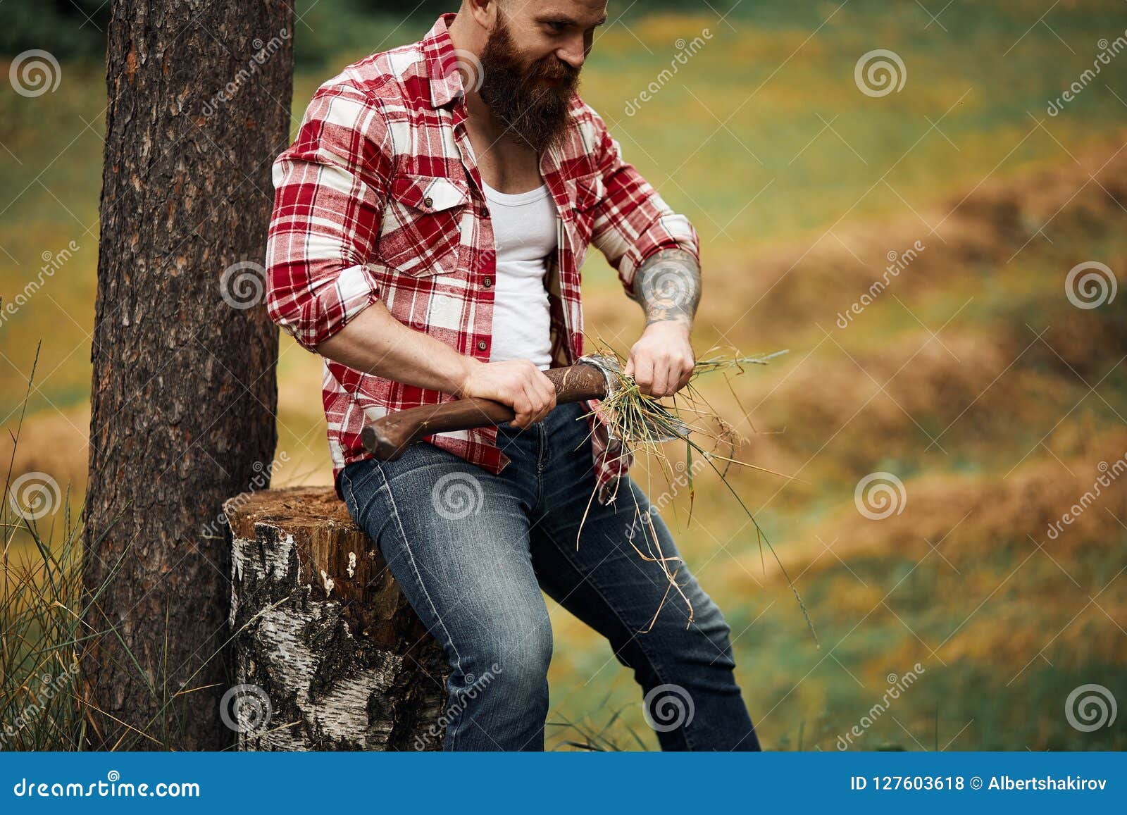 Bearded Man Wipes Clean Axe with Leaves. Bearded Axeman. Stock Photo ...
