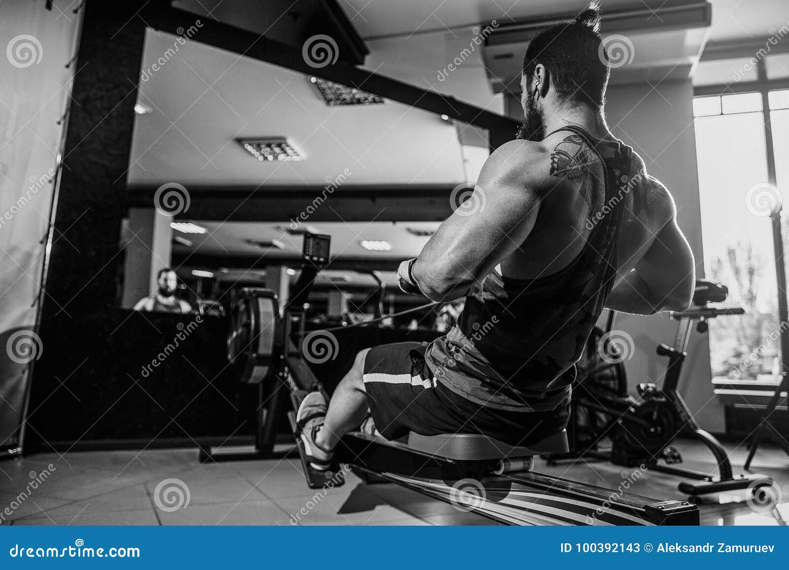 Muscular Fit Man Using Rowing Machine at Gym Stock Image - Image of ...