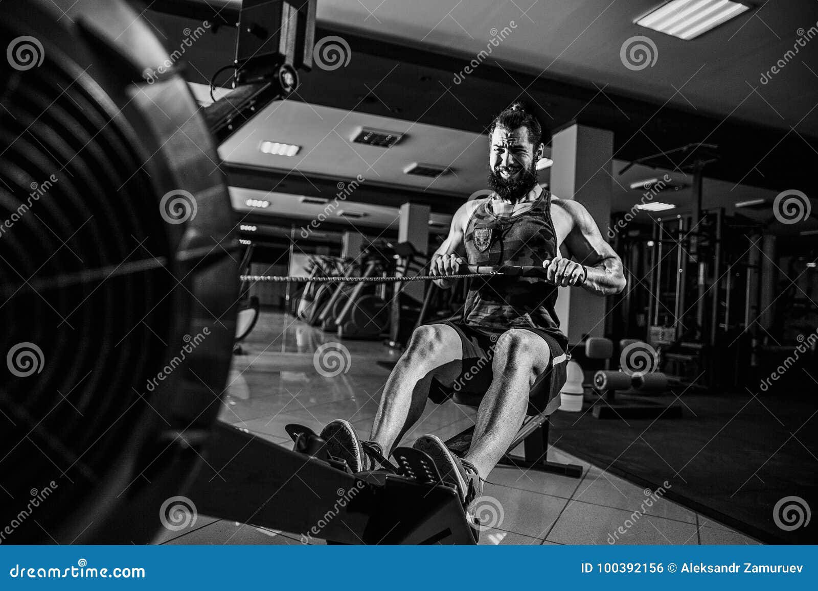 Muscular Fit Man Using Rowing Machine at Gym Stock Photo - Image of ...