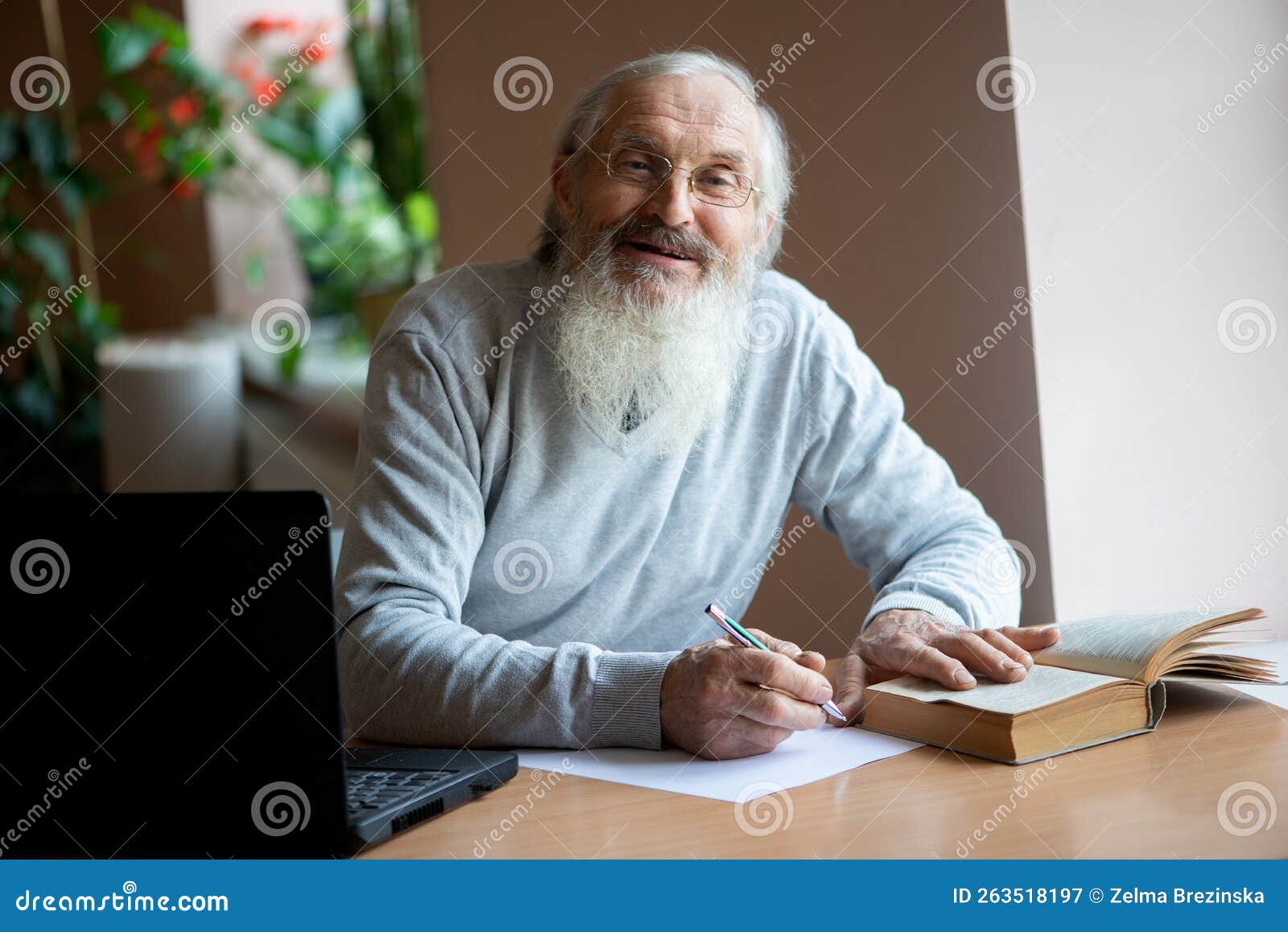 Senior Man with Laptop and Book Sitting at Table and Write Notes Stock ...